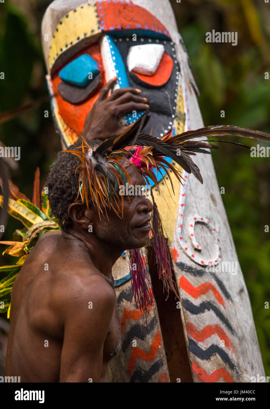 Small Nambas tribesman beating on a slit gong drum during the palm tree ...