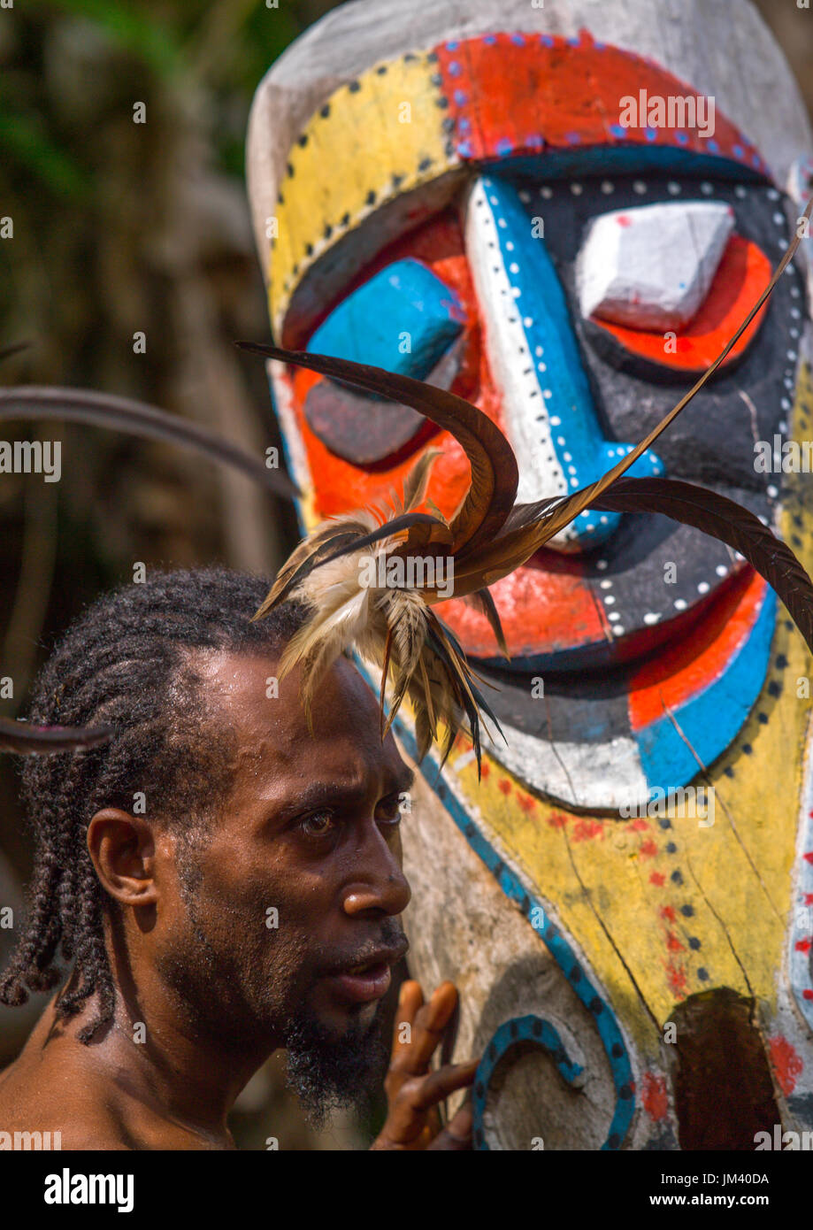 Small Nambas tribesman beating on a slit gong drum during the palm tree ...