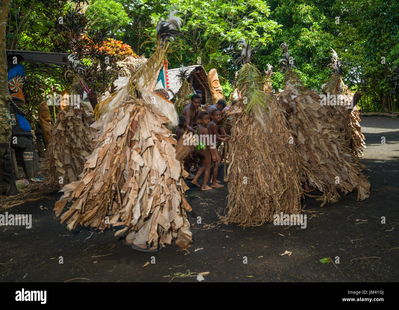 Tribesmen dressed in colorful masks and costumes made from the leaves ...