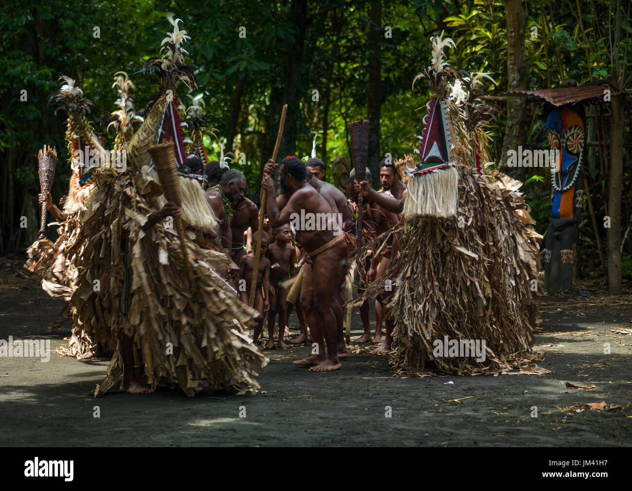 Tribesmen dressed in colorful masks and costumes made from the leaves ...