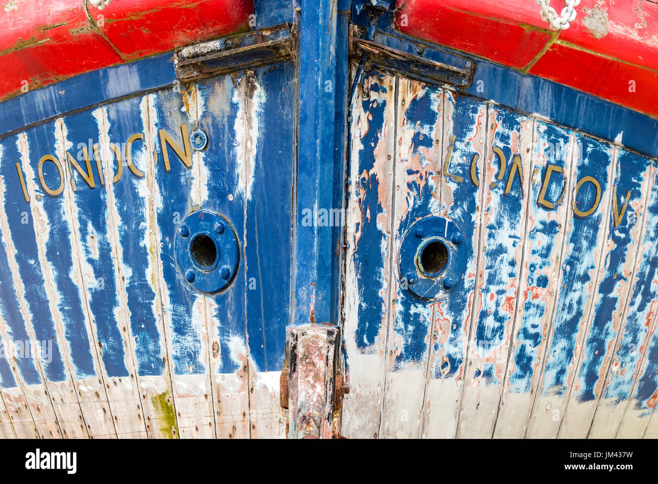 Dry docked former lifeboat. Bows with blue paint peeling and heavily ...