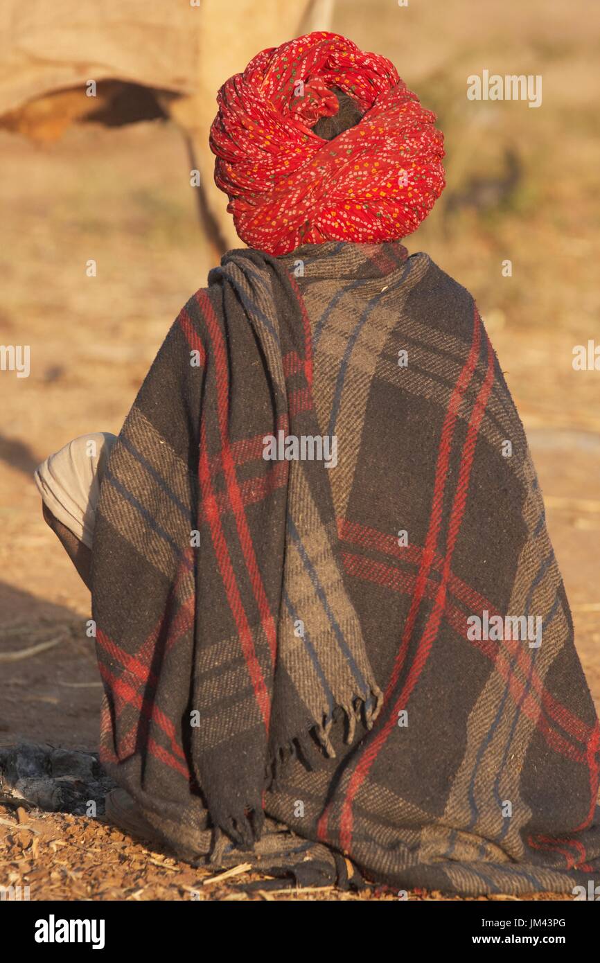 Nomadic man sitting on the ground in the desert of Rajasthan, India ...