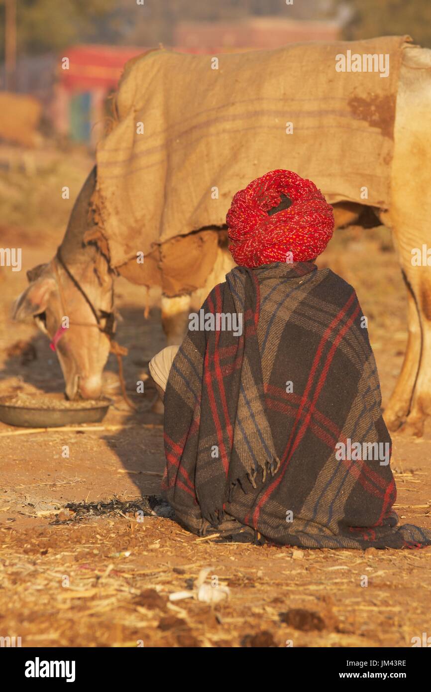 Nomadic man sitting on the ground in the desert of Rajasthan, India ...