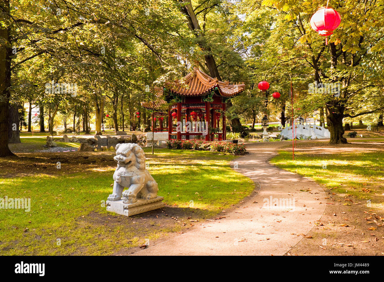 Chinese garden with pagoda pavilion, lanterns and guarding lion in ...