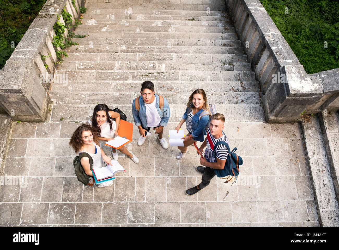 Group of attractive teenage students at the stone steps in front of ...