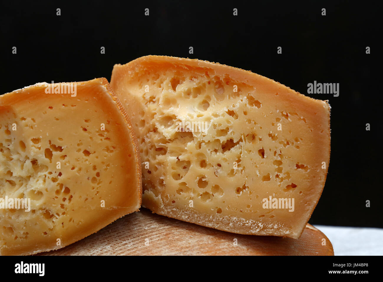 Cut slice block section of old aged matured hard artisan cheese over ...