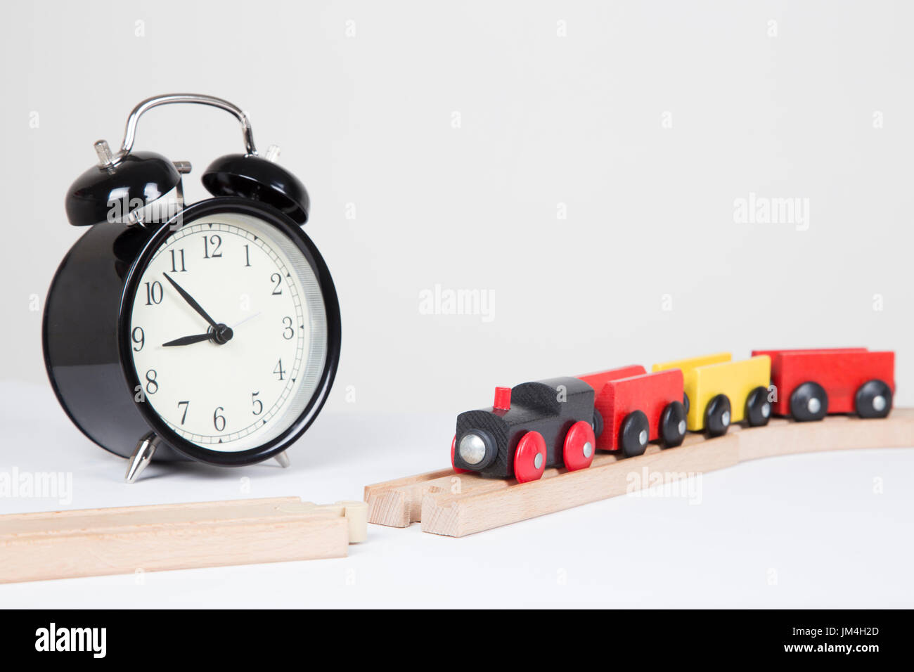 Alarm clock and toy train, delay concept Stock Photo - Alamy