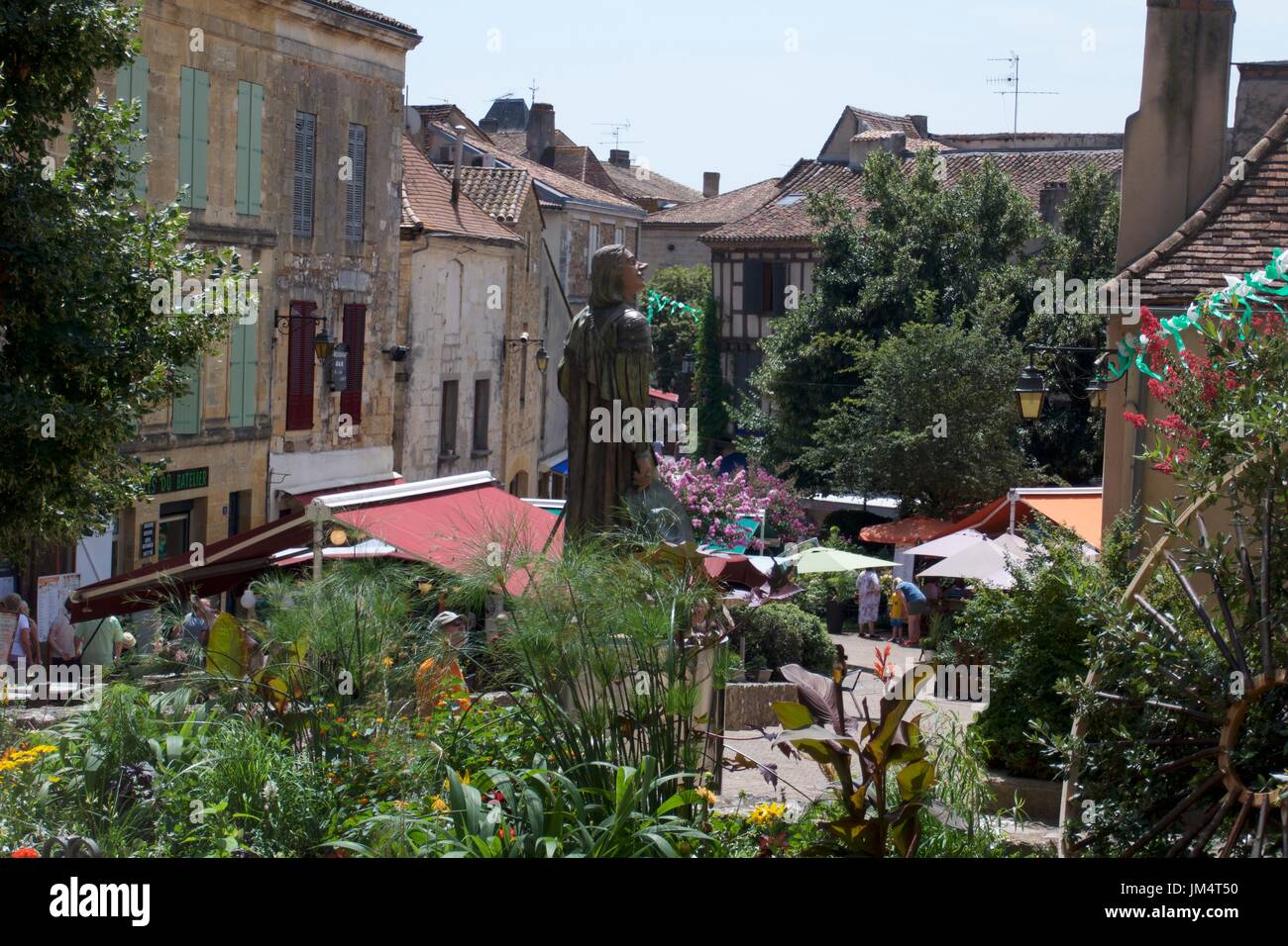 Statue and outdoor restaurants in traditional town square, Bergerac ...