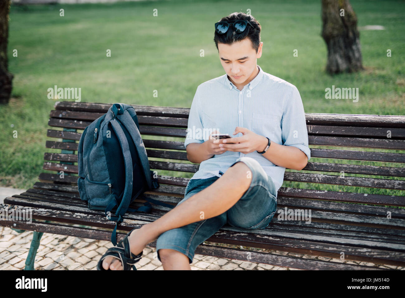 Teenager boy phone park bench hi-res stock photography and images - Alamy