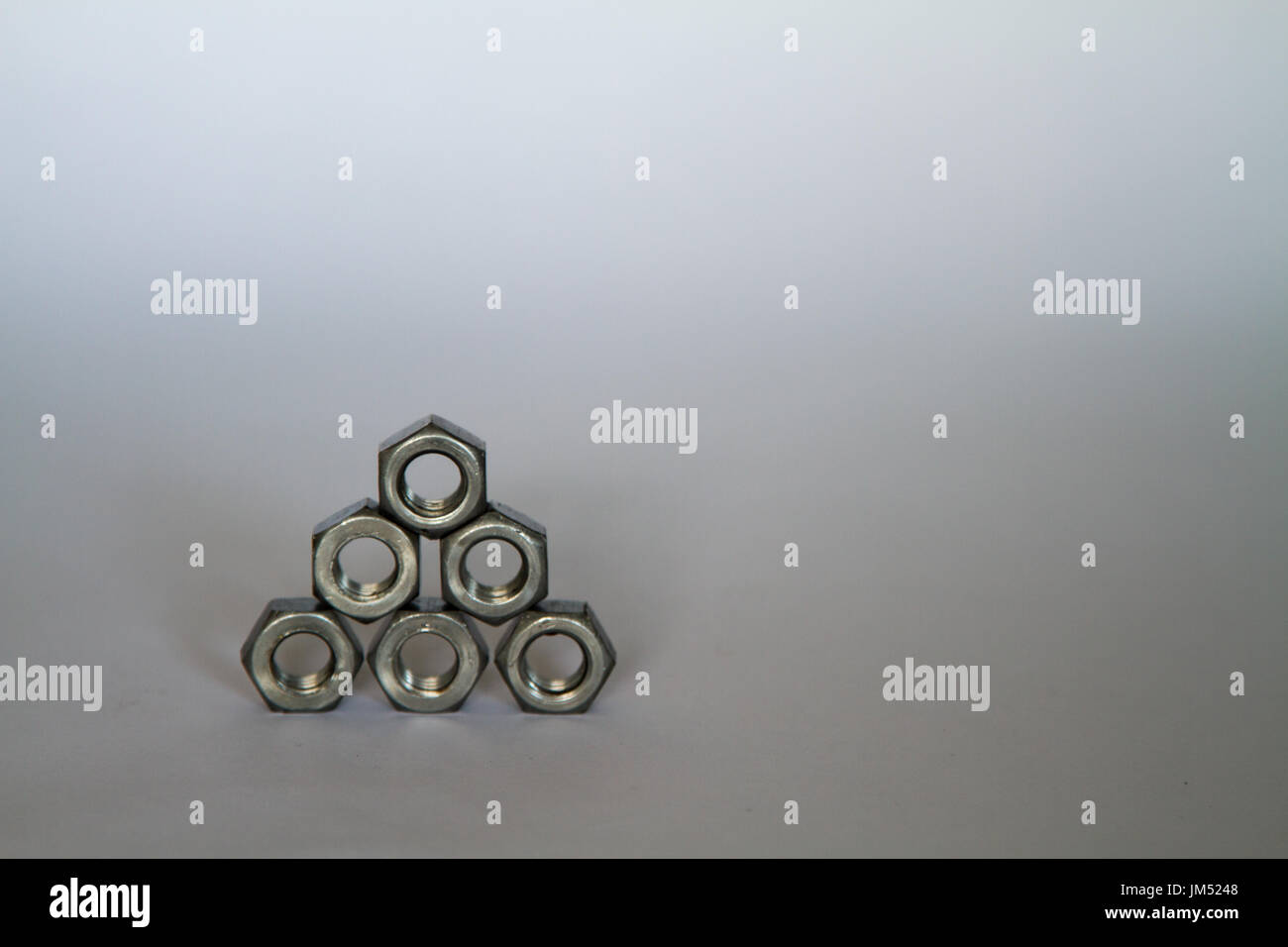 A Stacked triangle of HEX Nuts - background Stock Photo - Alamy