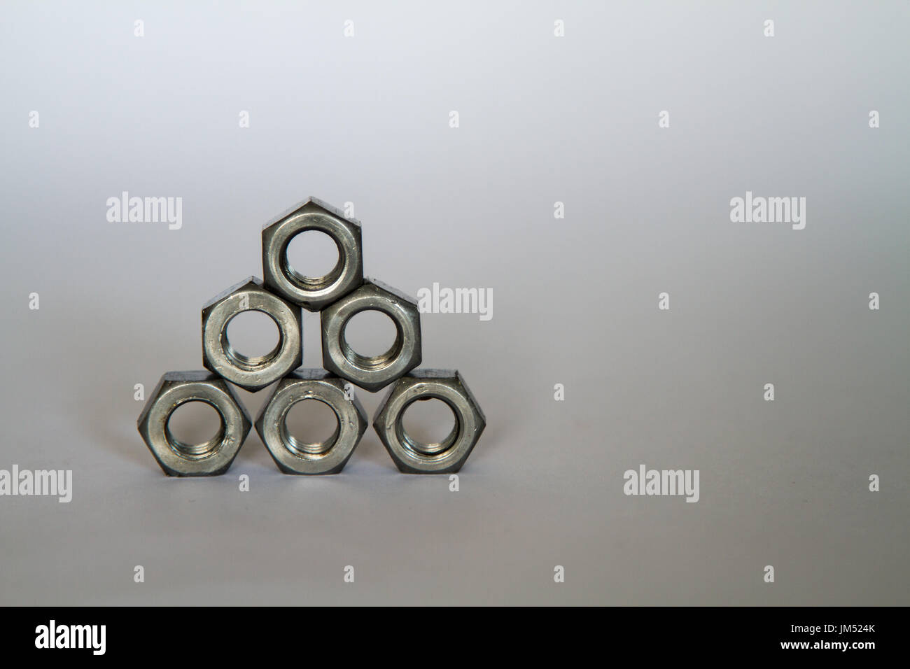 A Stacked triangle of HEX Nuts - background Stock Photo - Alamy