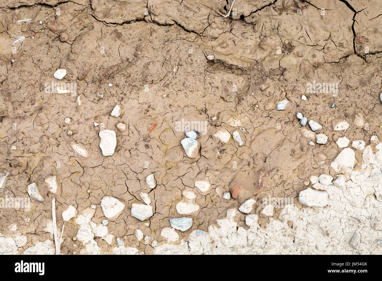 cracked bottom of dried puddle on country road Stock Photo - Alamy