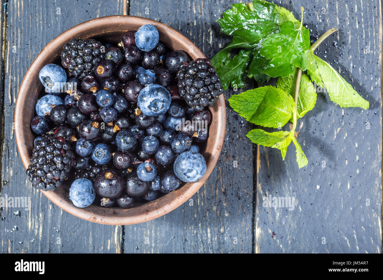 Forest berries in a clay plate. Berries with water drops. Deep depth of ...