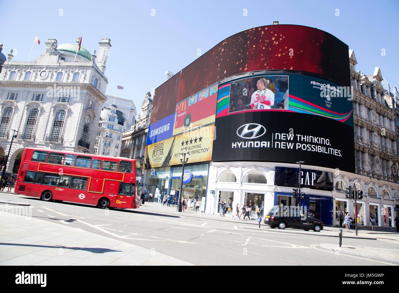 LONDON, UK - AUG 12, 2016. Red bus passing big screens in Piccadilly ...