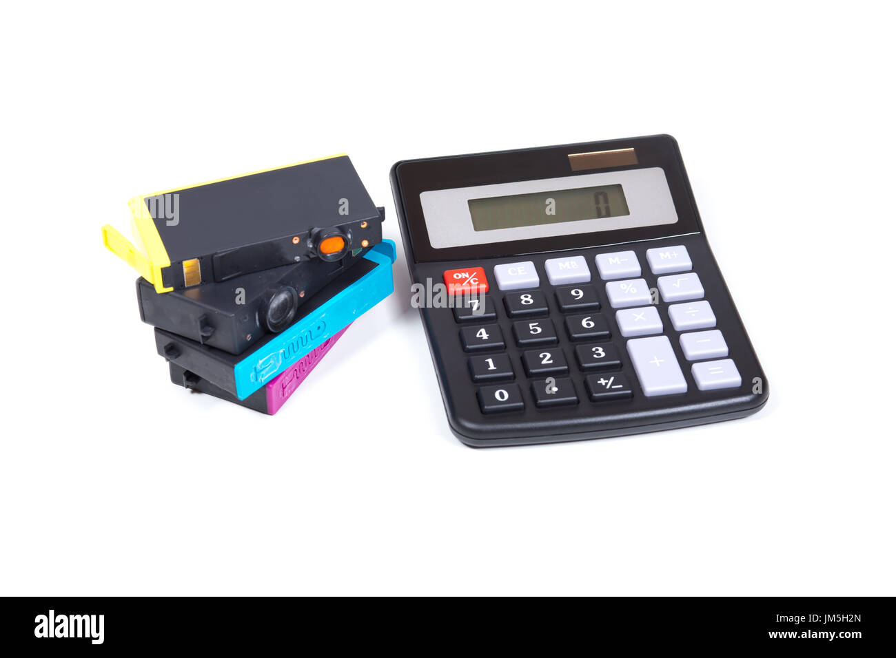 Stack of jet-ink color printer cartridges and simple calculator, viewed ...