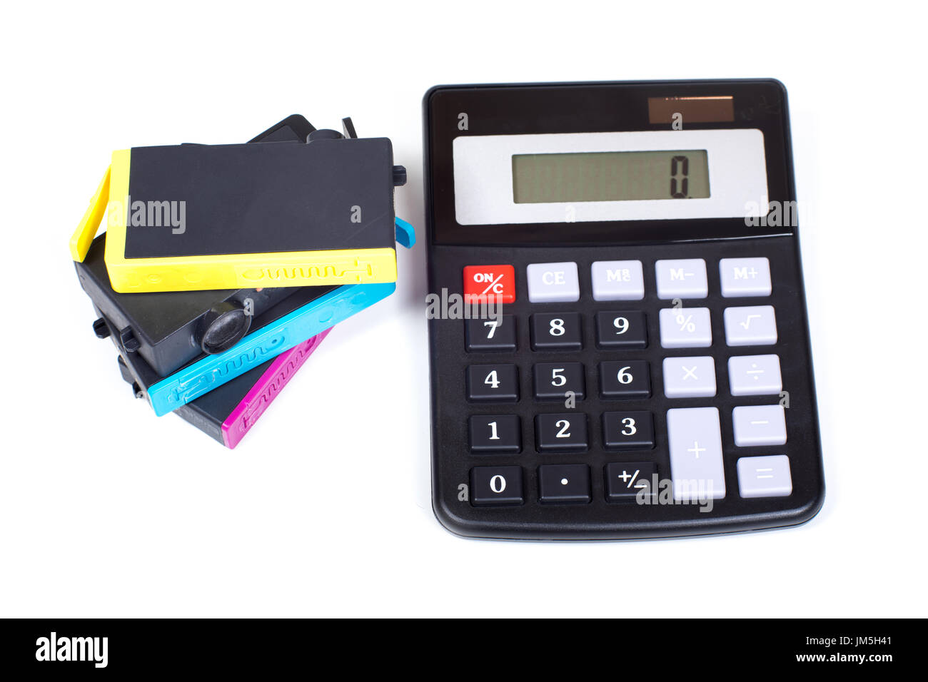 Stack of jet-ink printer cartridges and simple calculator viewed from ...