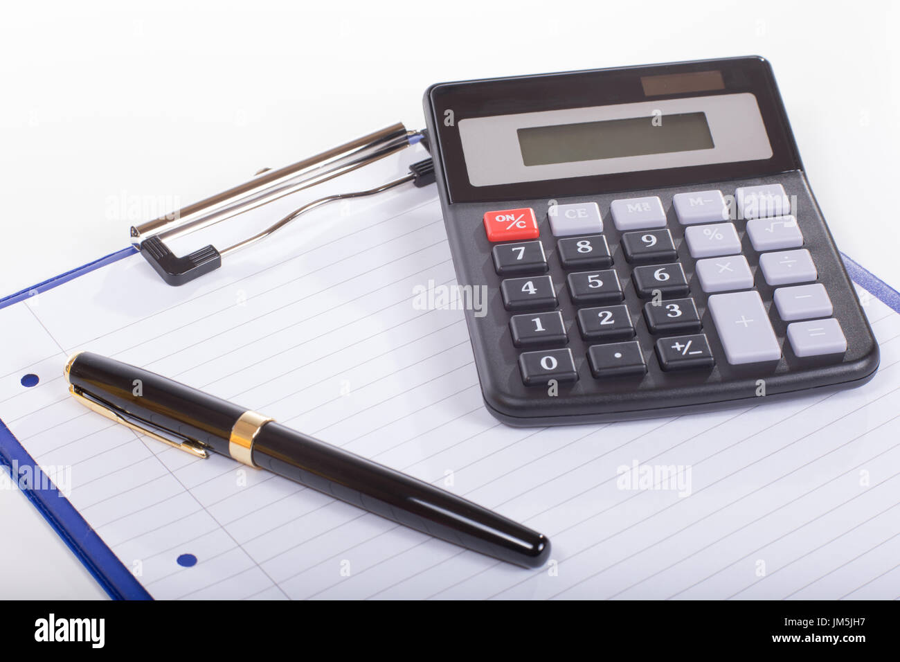 Accounting concept with calculator and pen over clean sheet of lined ...