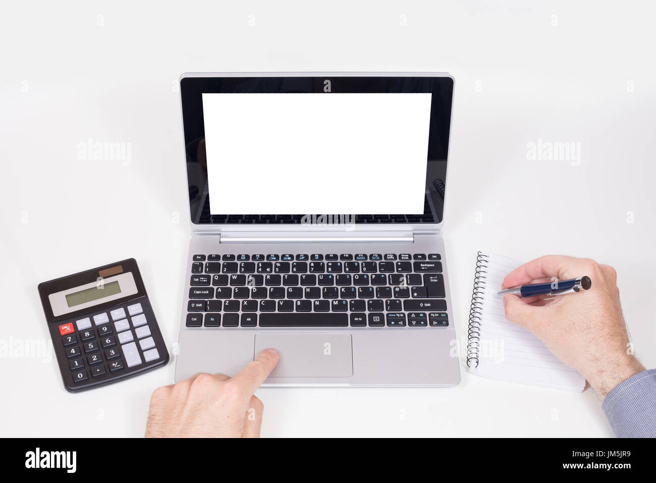 Writing with pen while working on computer. Male hands viewed from ...