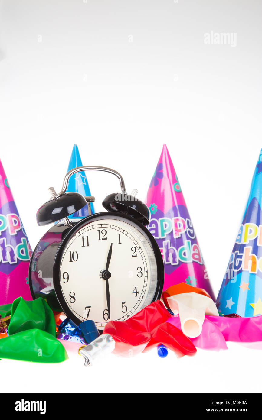 Kids party concept with alarm clock surrounded by party hats, ballons ...