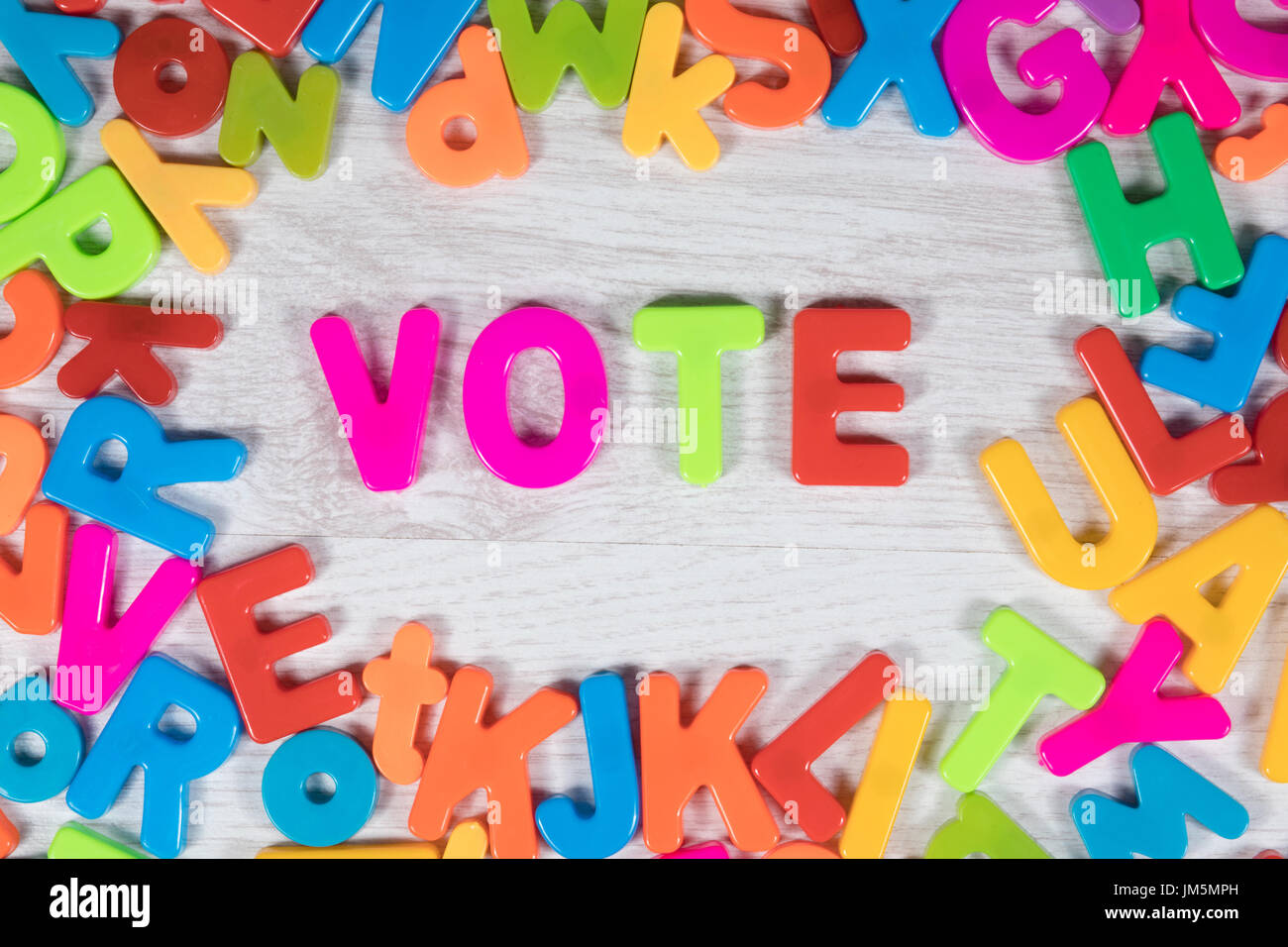 Brightly colored magnet letters create border around the word vote ...