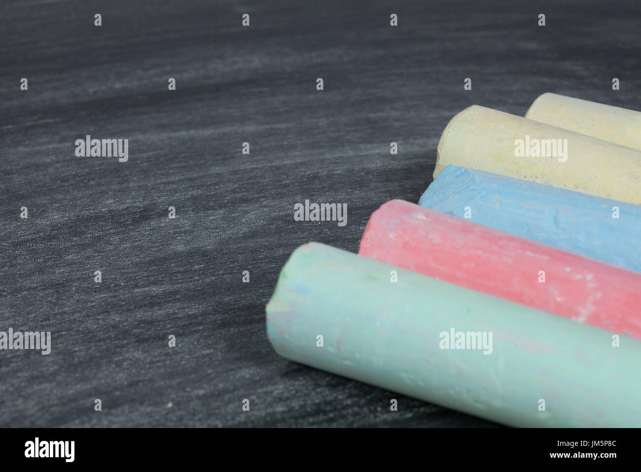 Colored chalk on a blackboard in a school, education and learning ...