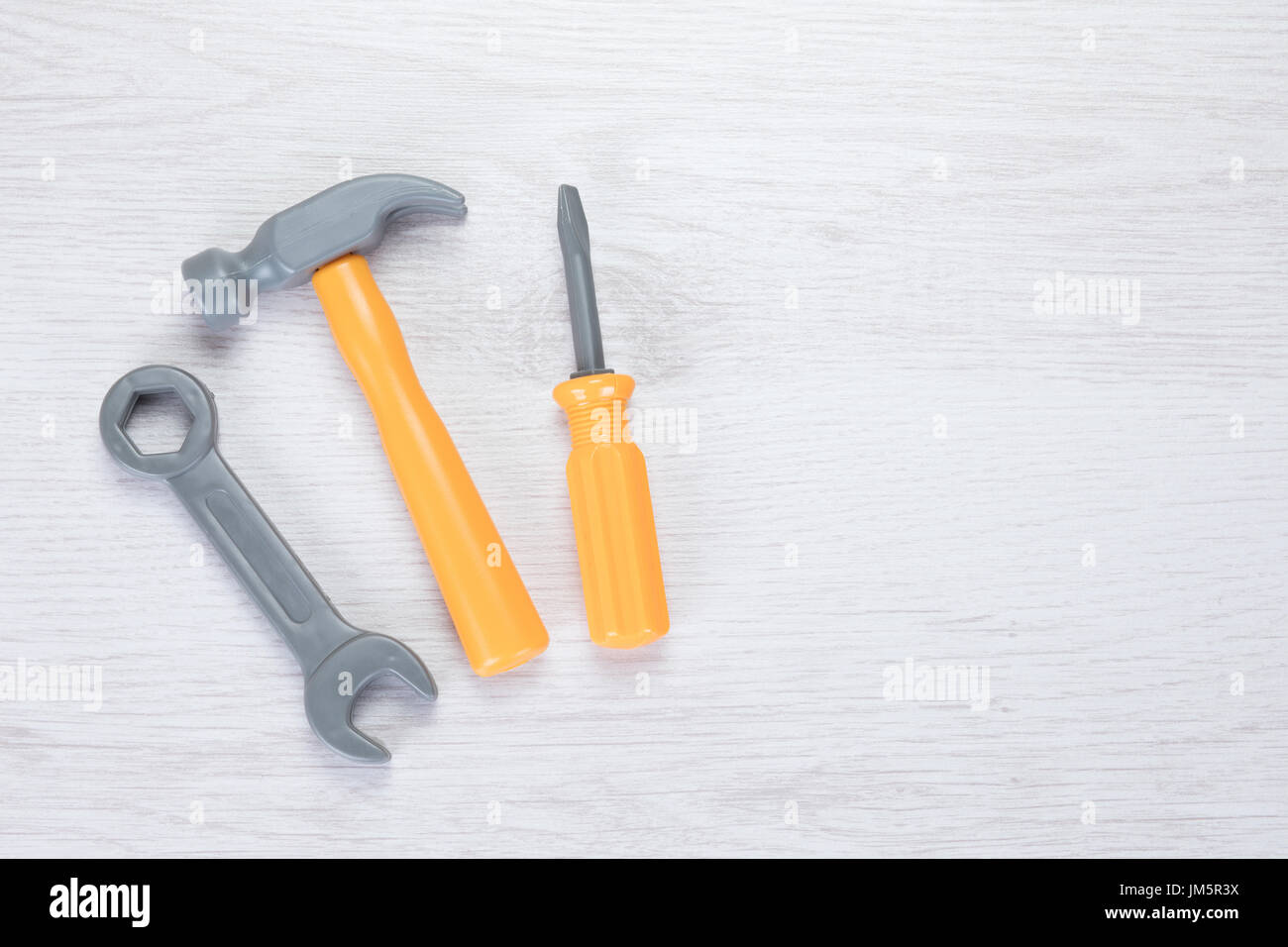 Plastic toy screwdriver, wrench and hammer on white background with ...