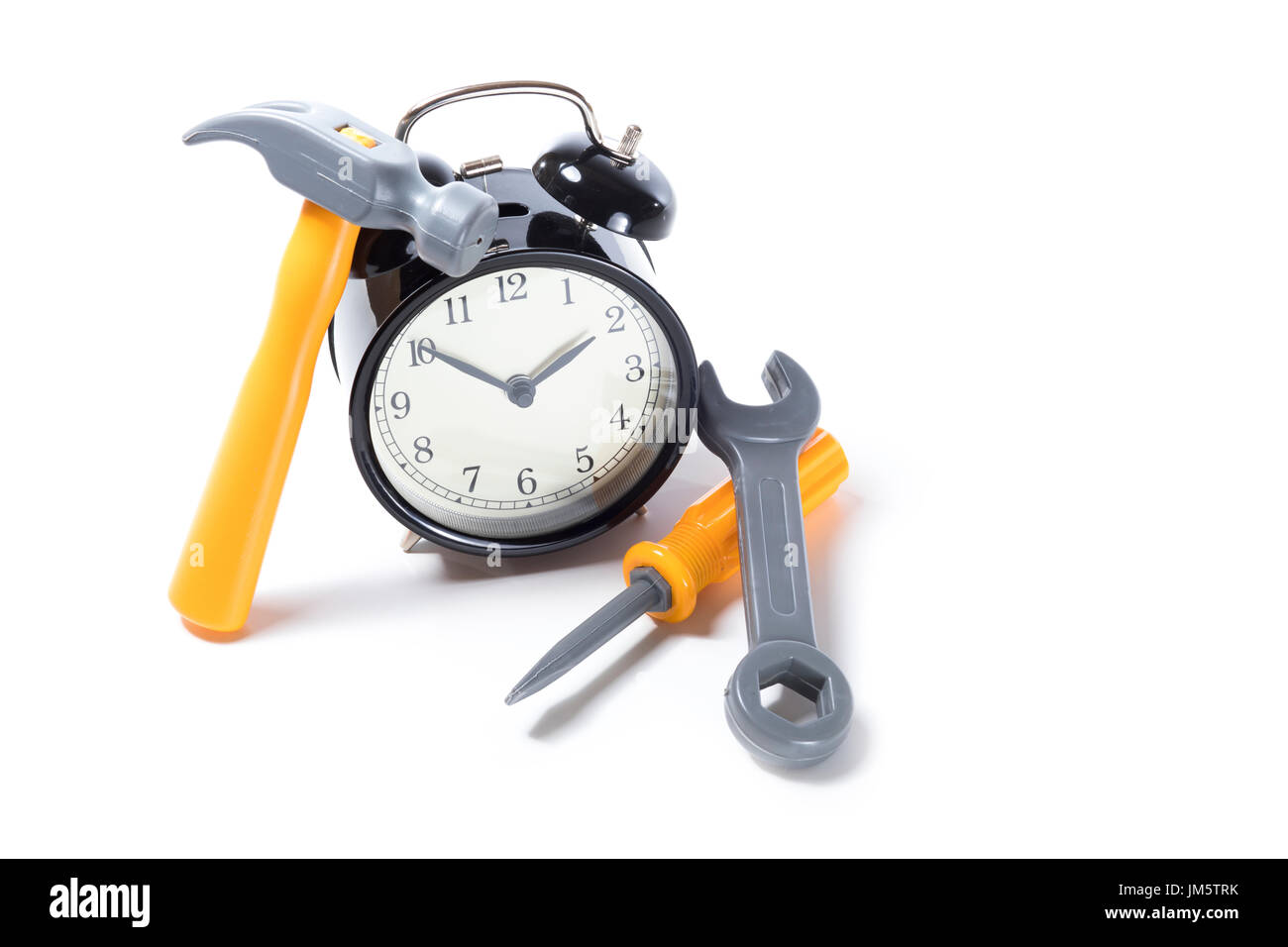 High angle of classic alarm clock with pile of plastic toy tools ...