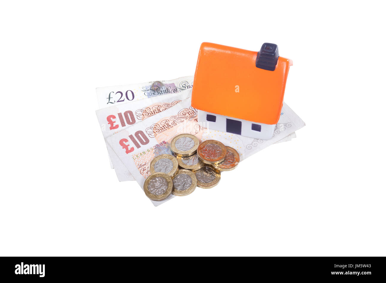 Pile of British pound coins and notes with a small model house in a ...