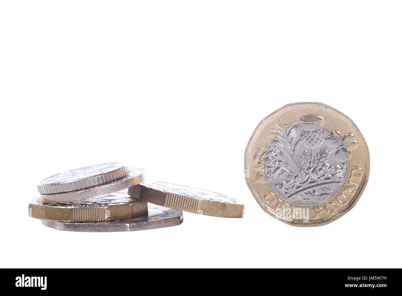 Close up of the new British one pound coin with a pile and one standing ...