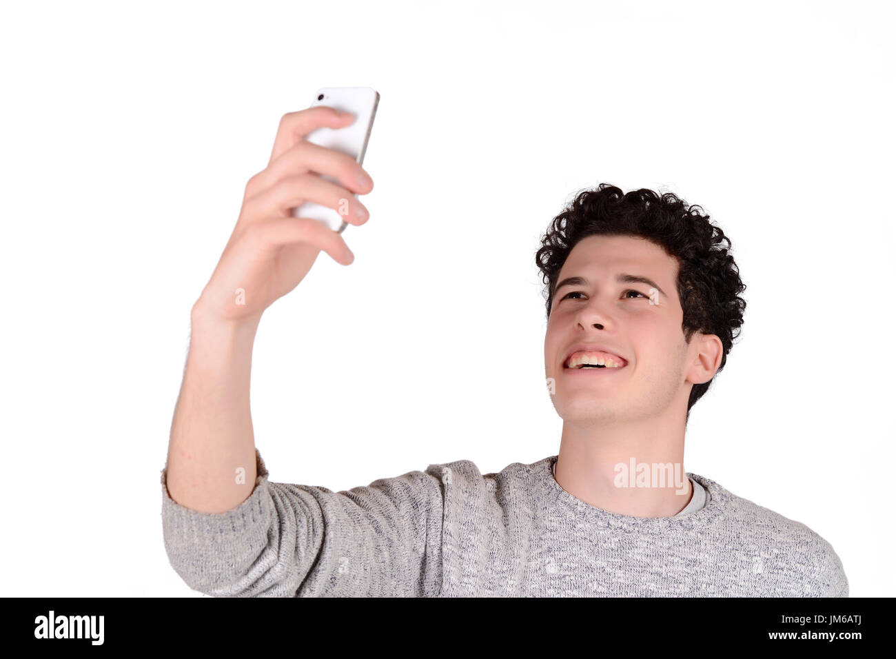 Portrait of a young man taking selfie with smartphone. Isolated white ...