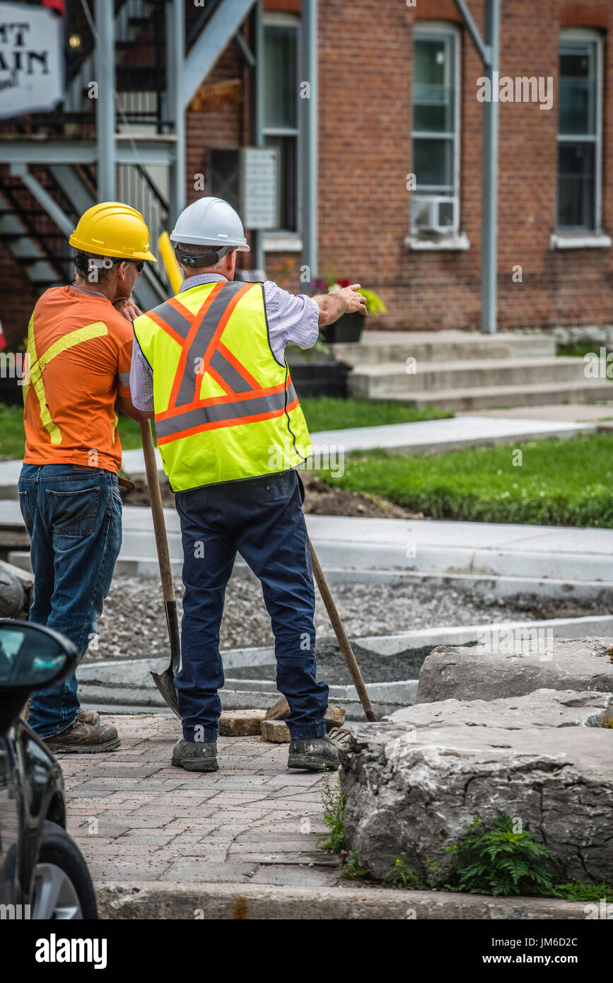Canadian industrial construction workers laying paving on streets in ...