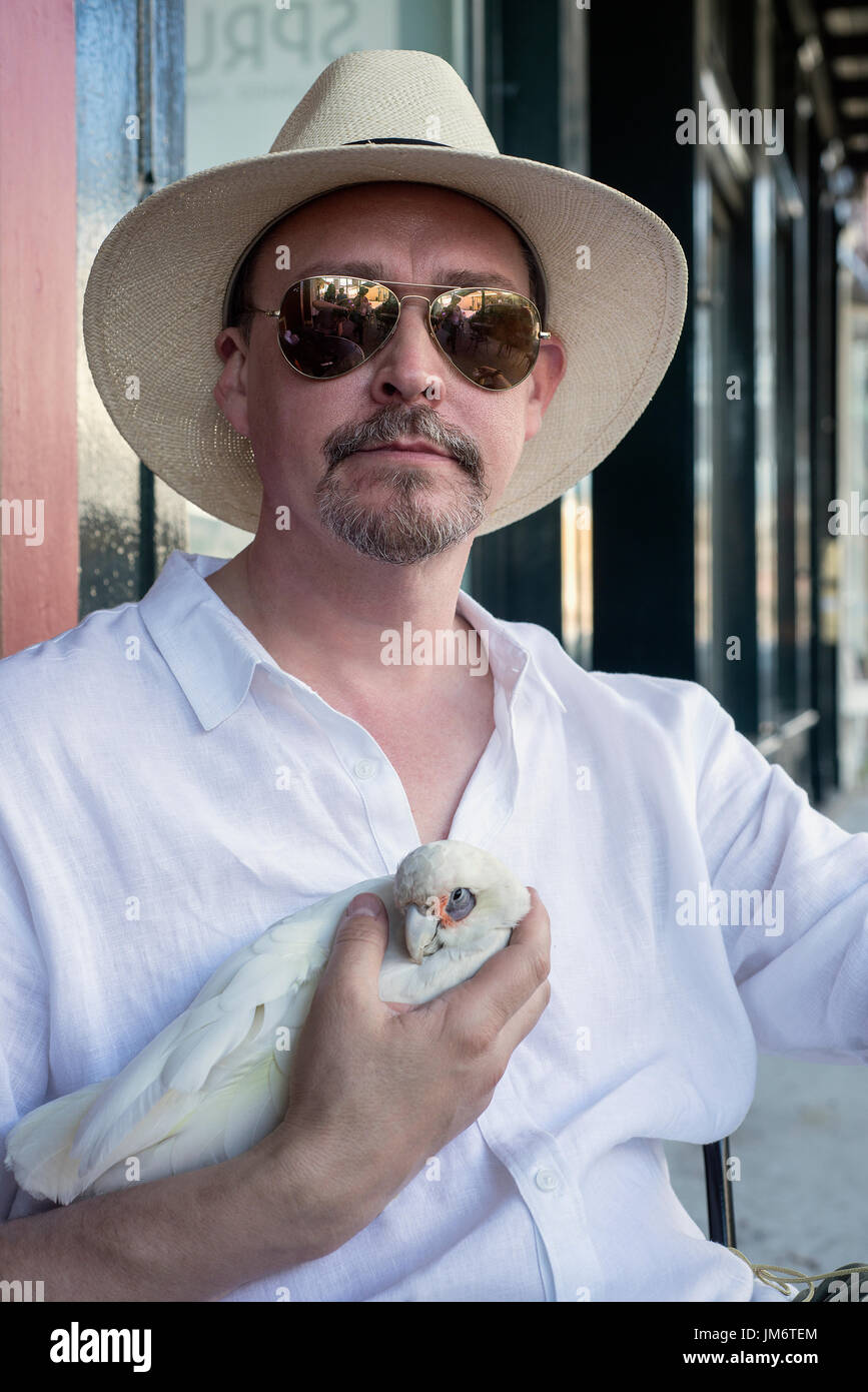 A man holding his pet cockatoo Stock Photo - Alamy
