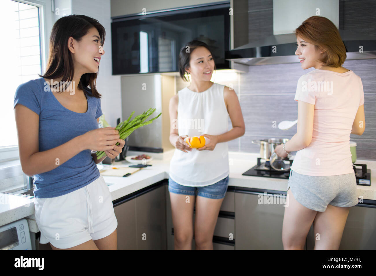 Best female friends cooking in kitchen Stock Photo - Alamy