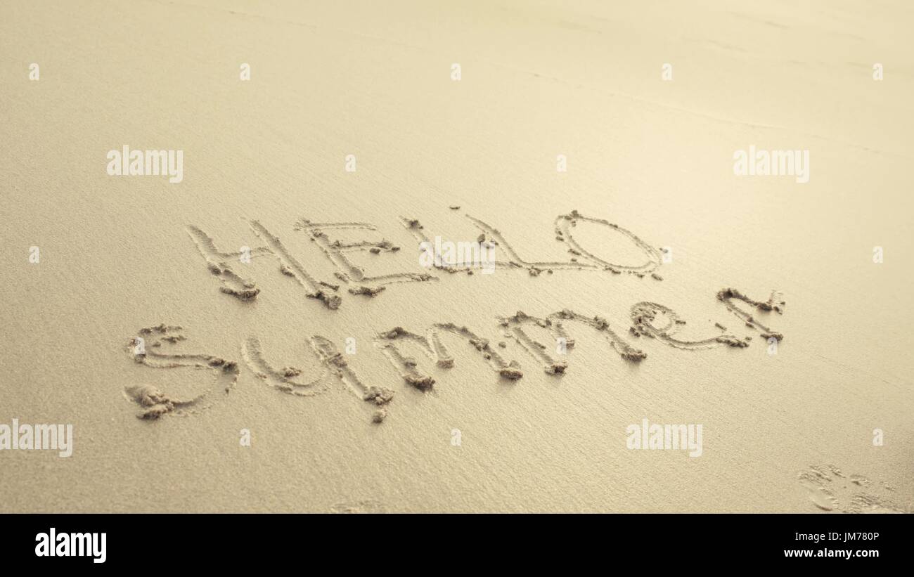 HELLO SUMMER written on the beach sand washed aways by waves Stock ...