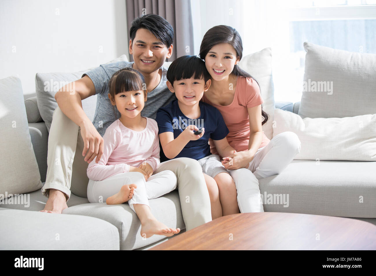 Happy young Chinese family watching TV Stock Photo - Alamy