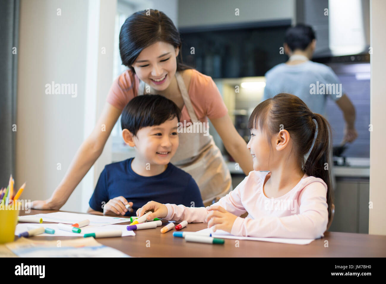 Happy Chinese siblings drawing pictures together at home Stock Photo ...
