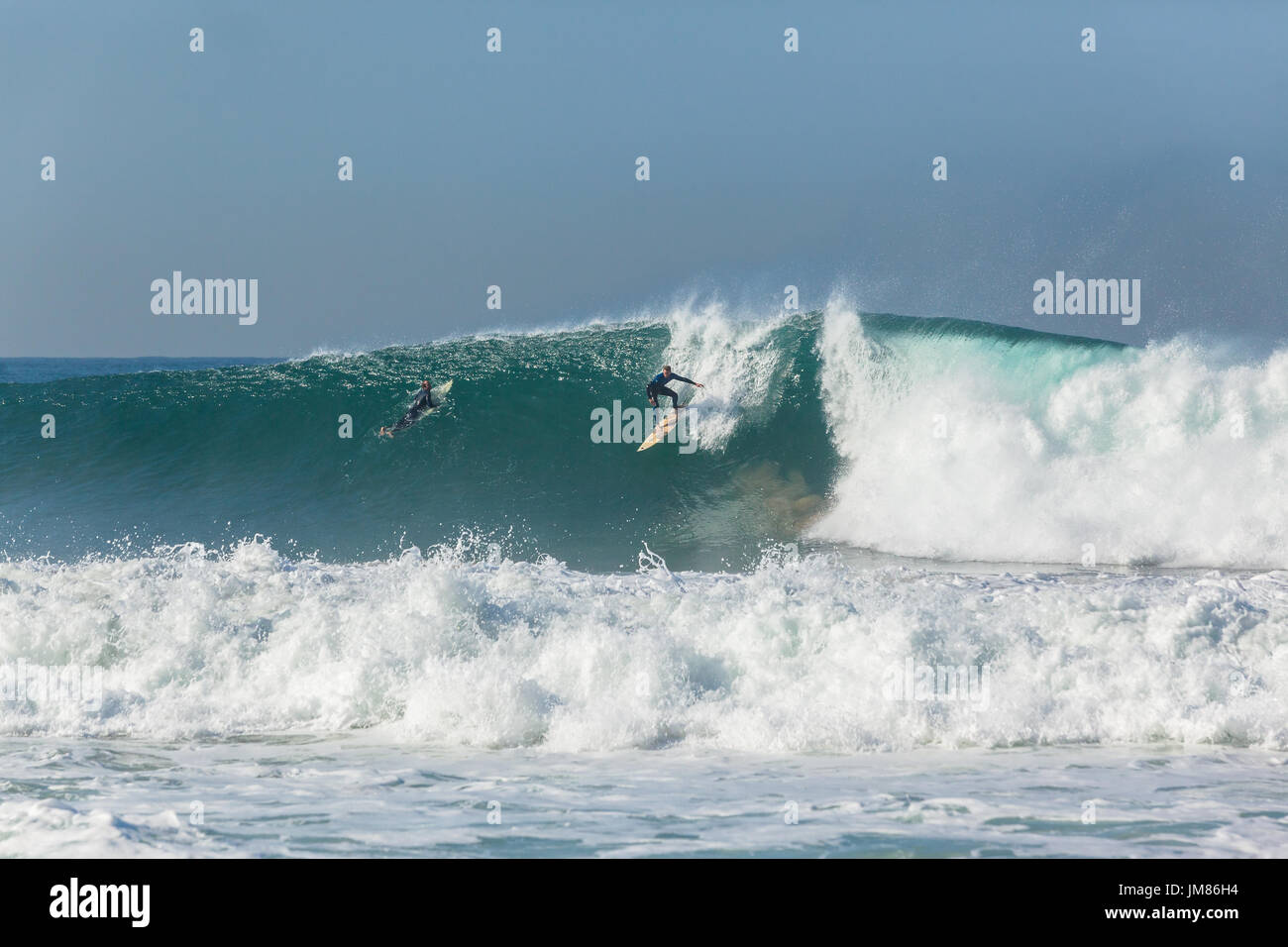 Surfer surfing take off to ride large hollow ocean wave Stock Photo - Alamy