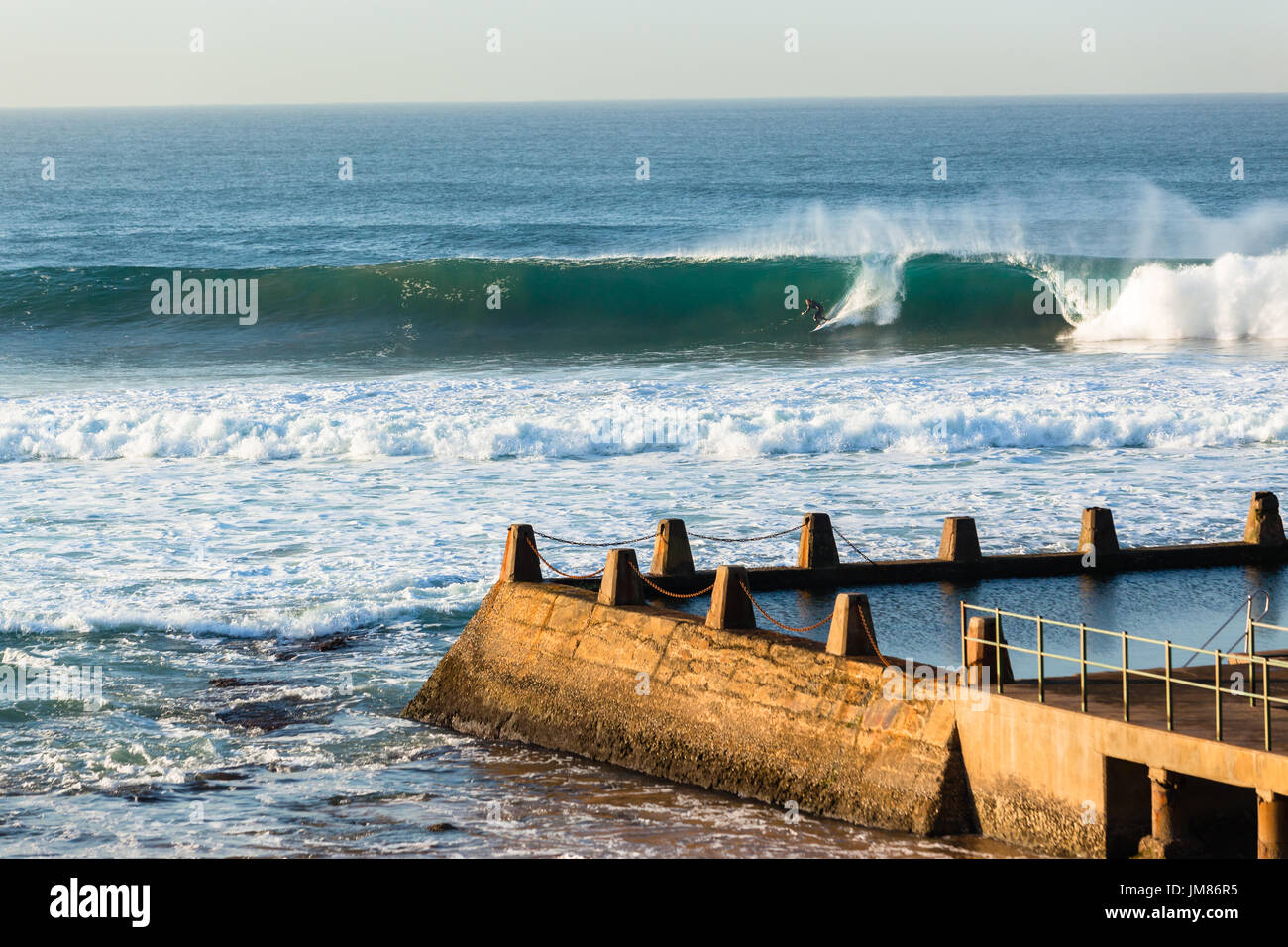 Surfer surfing ocean wave front of beach tidal swimming pool Stock ...