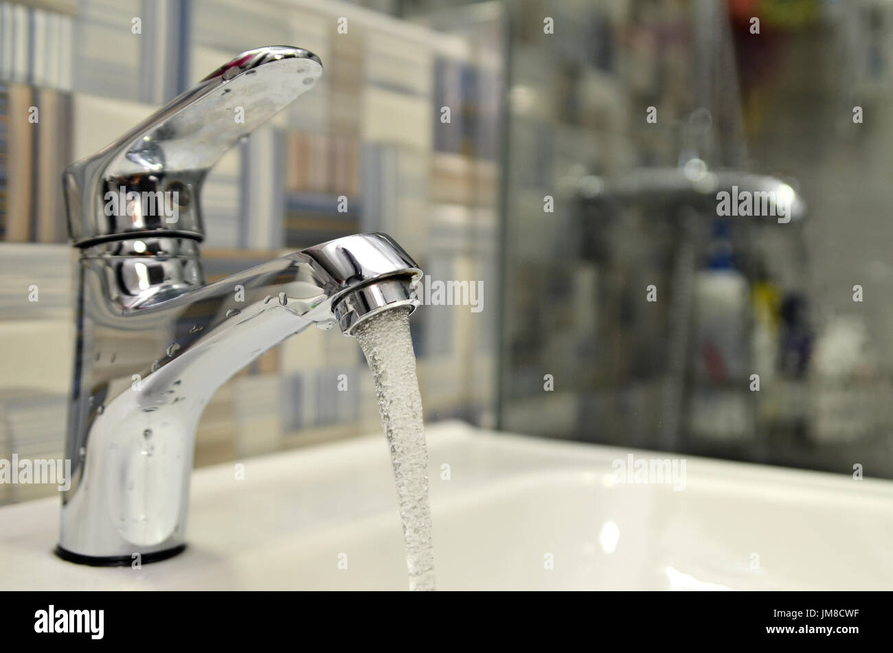 Opened water tap in the washroom. Save water concept Stock Photo - Alamy