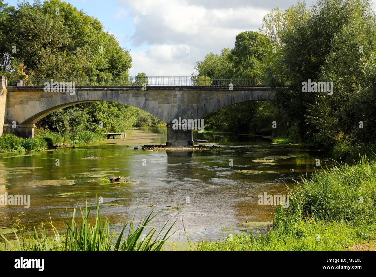 An Old Stone Archway River Bridge over a tranquil river in the Chenin ...