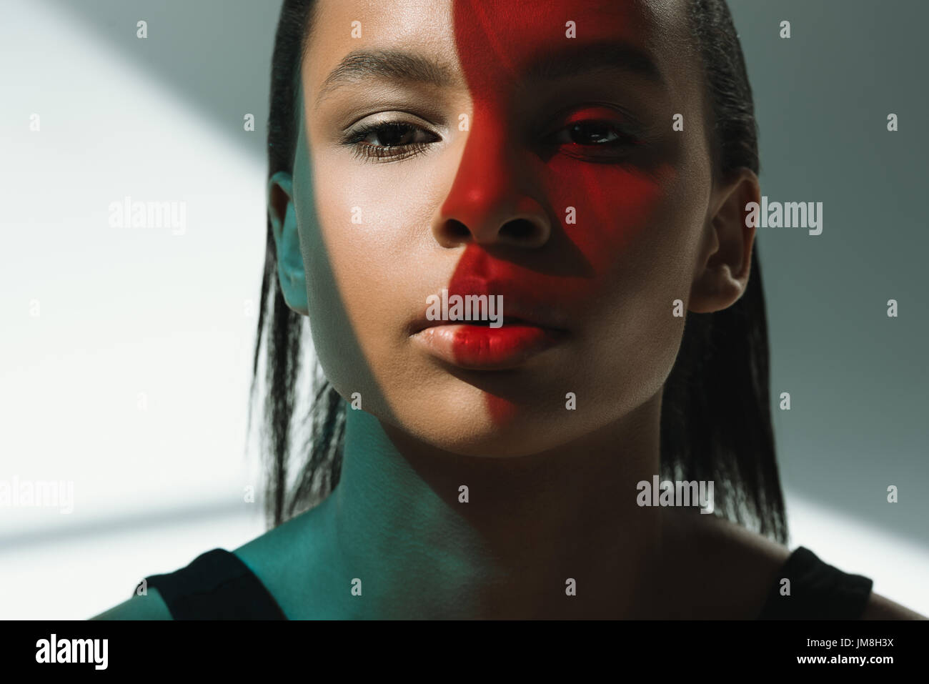 portrait of african american seductive stylish model with red shadow on ...