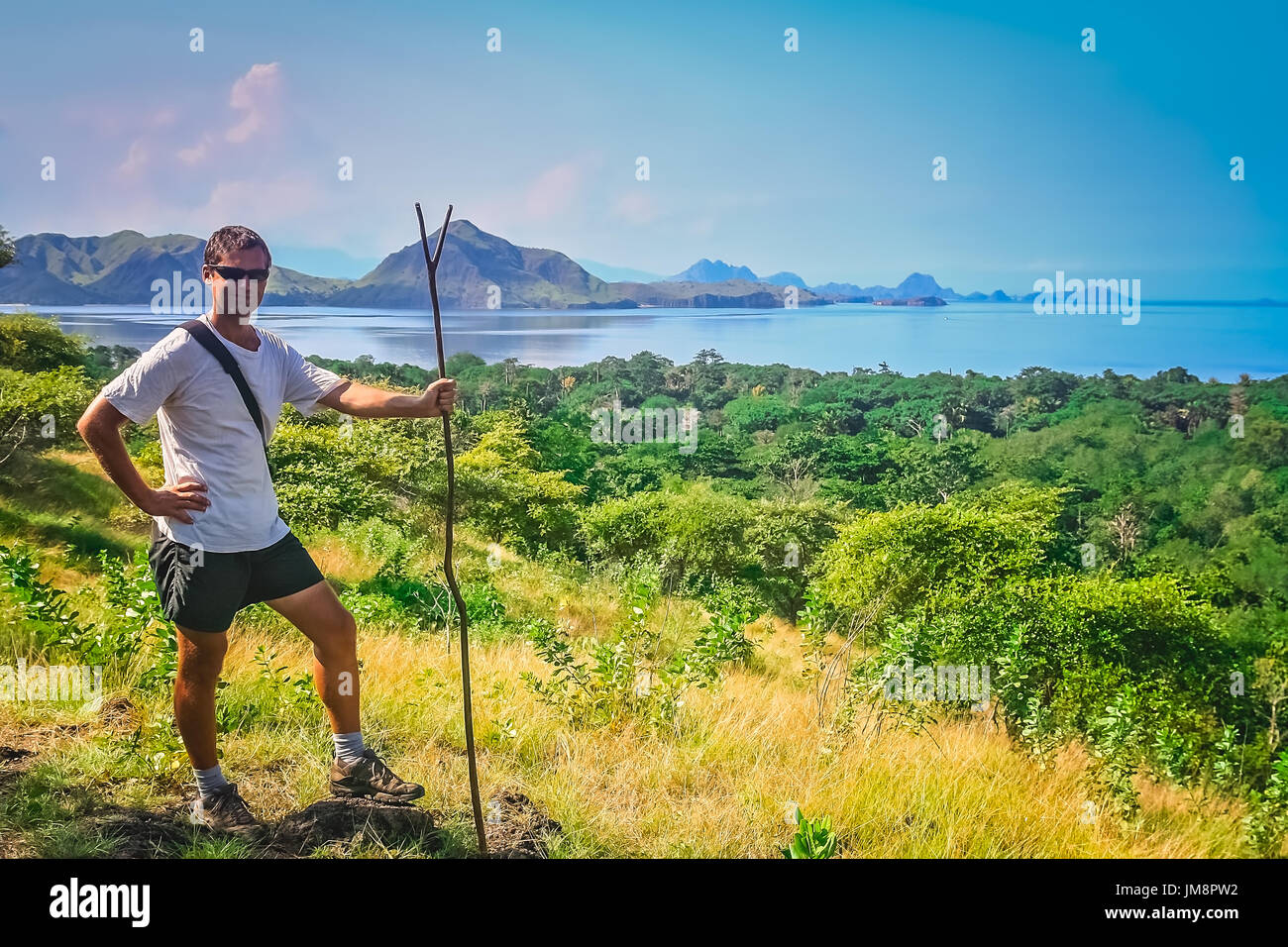Trekker with a primitive walking stick replacement standing on a hill ...