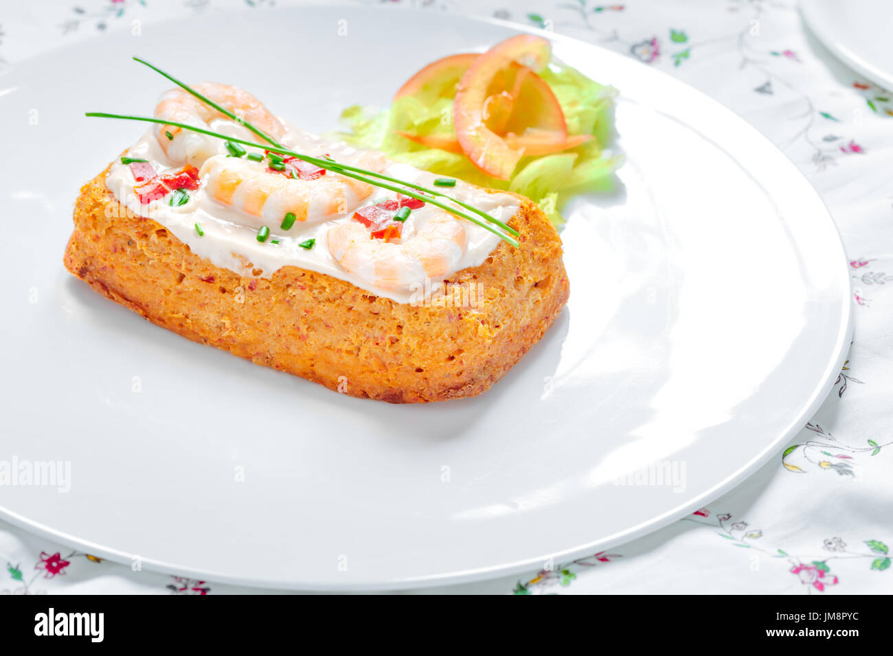 Traditional Spanish fish cake. Hake cake with tomato, shrimps, chive ...