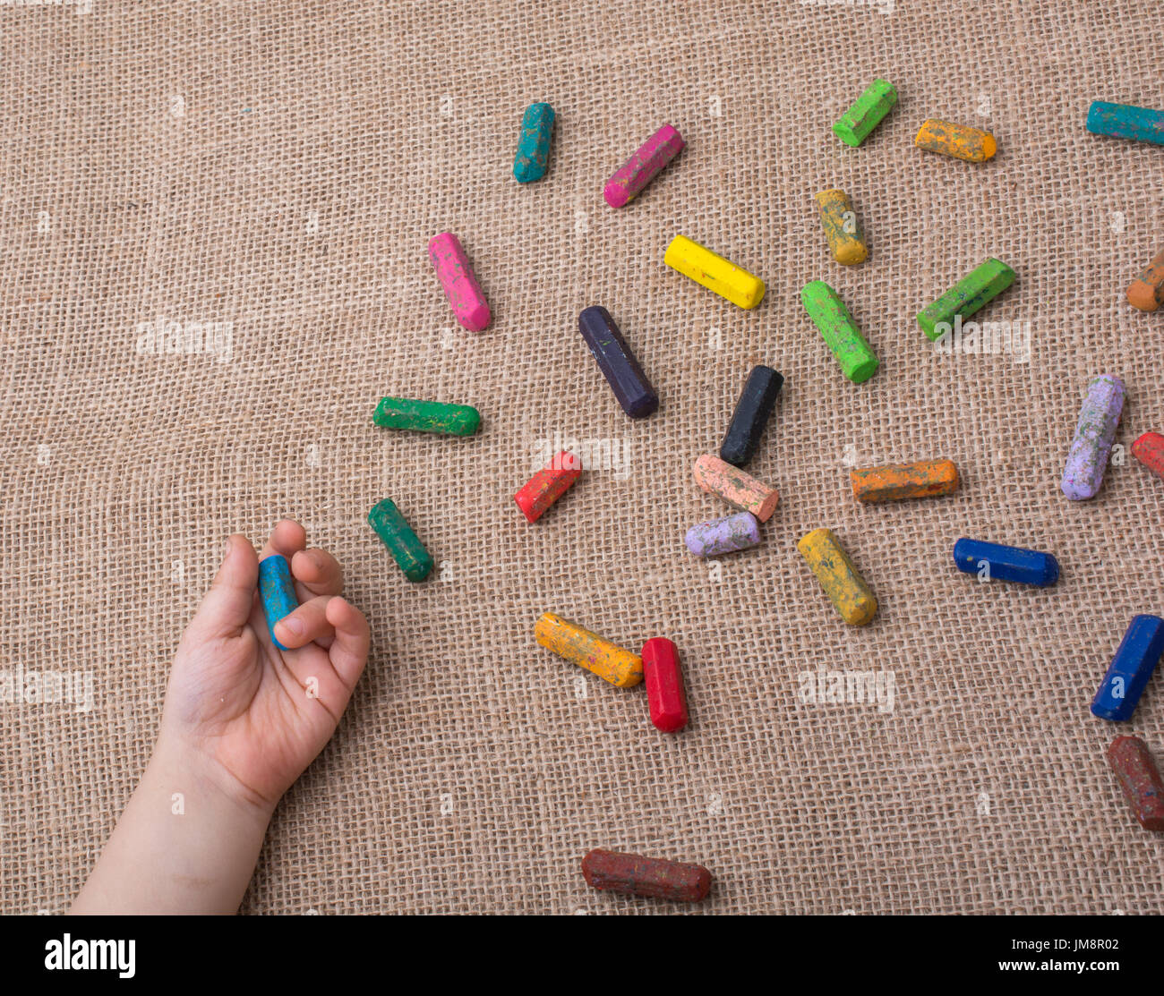 Used color crayons and a toddlers hand holding one Stock Photo - Alamy