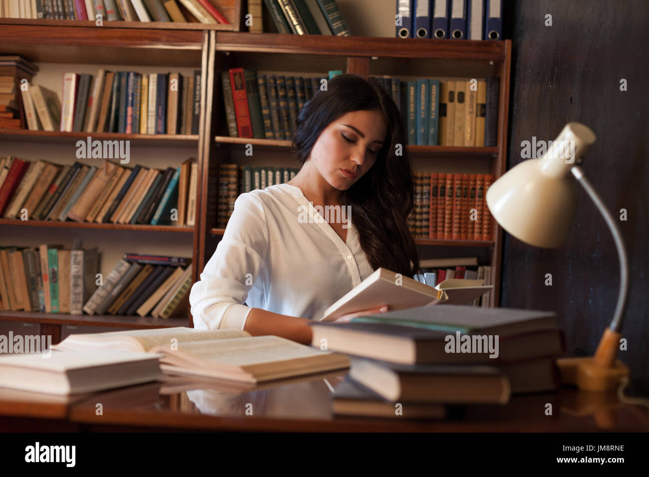 girl is preparing for the exam reading book at the library Stock Photo ...