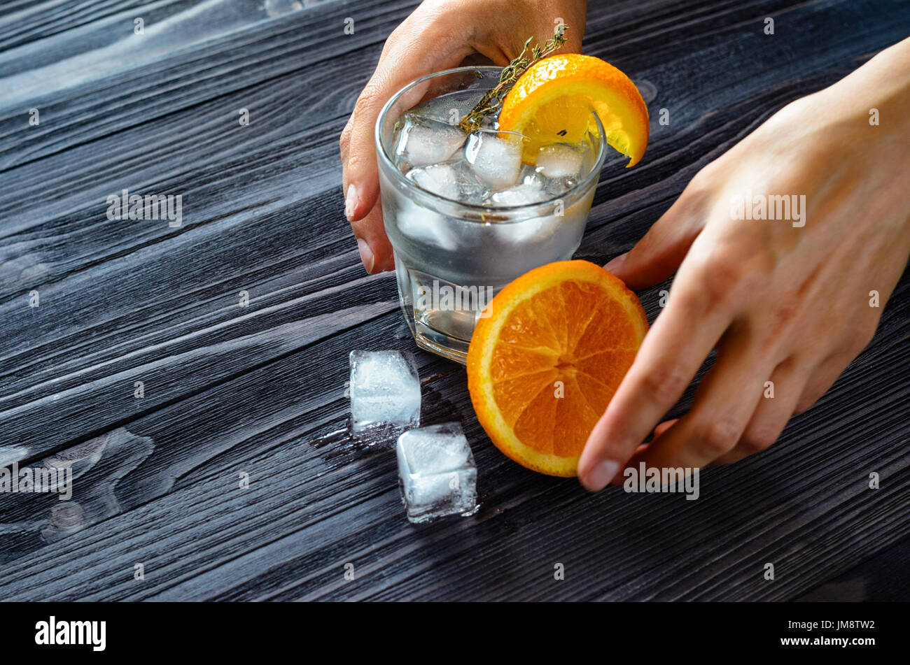 Preparation of a refreshing beverage with ice and citrus fruits on a ...
