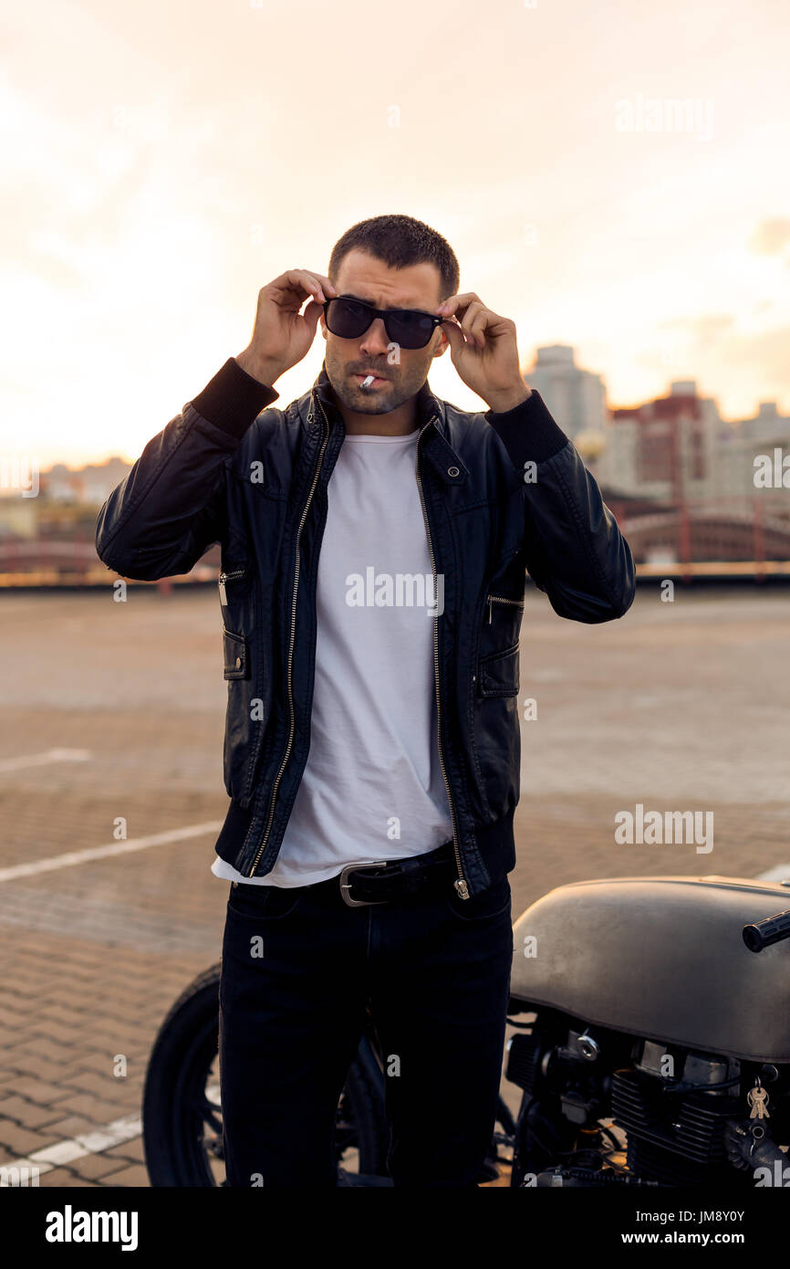 Closeup of a handsome rider man with beard and mustache in black biker ...