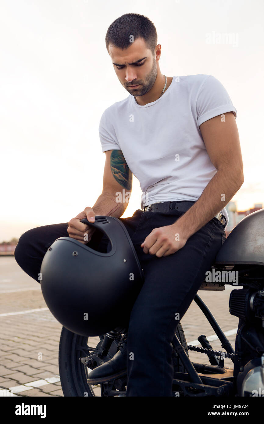 Close up of a handsome rider guy in white blank t-shirt with helmet ...