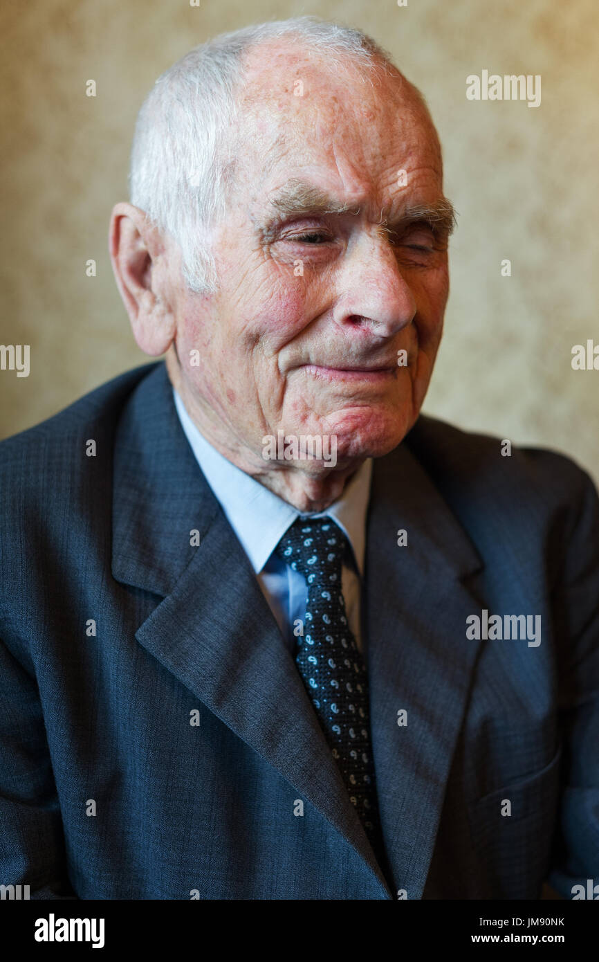 Handsome 80 plus year old senior man posing for a portrait in his house ...