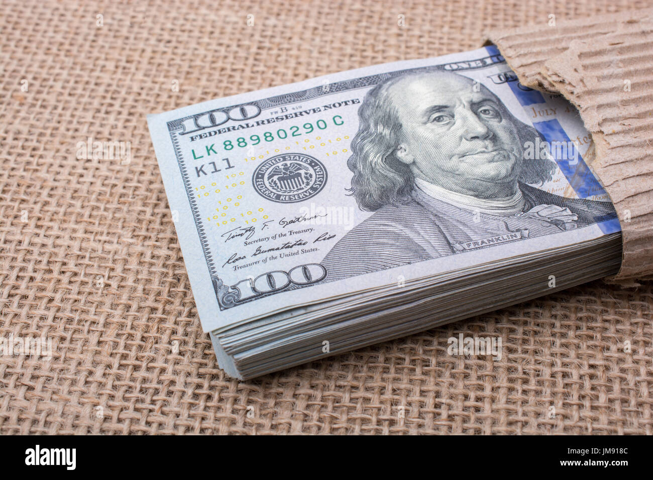 Banknote bundle of US dollar partly wrapped in cardboard Stock Photo ...